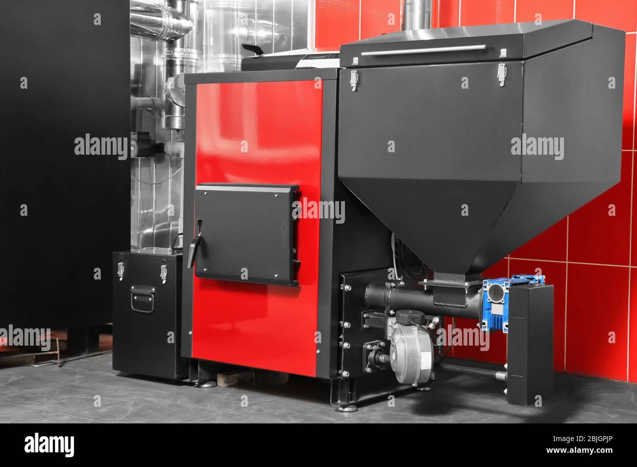 Solid fuel boiler against red wall Stock Photo - Alamy