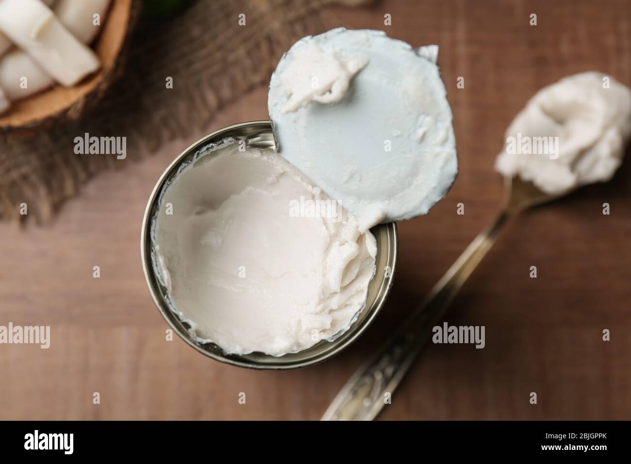 Coconut cream in opened tin on wooden table Stock Photo - Alamy