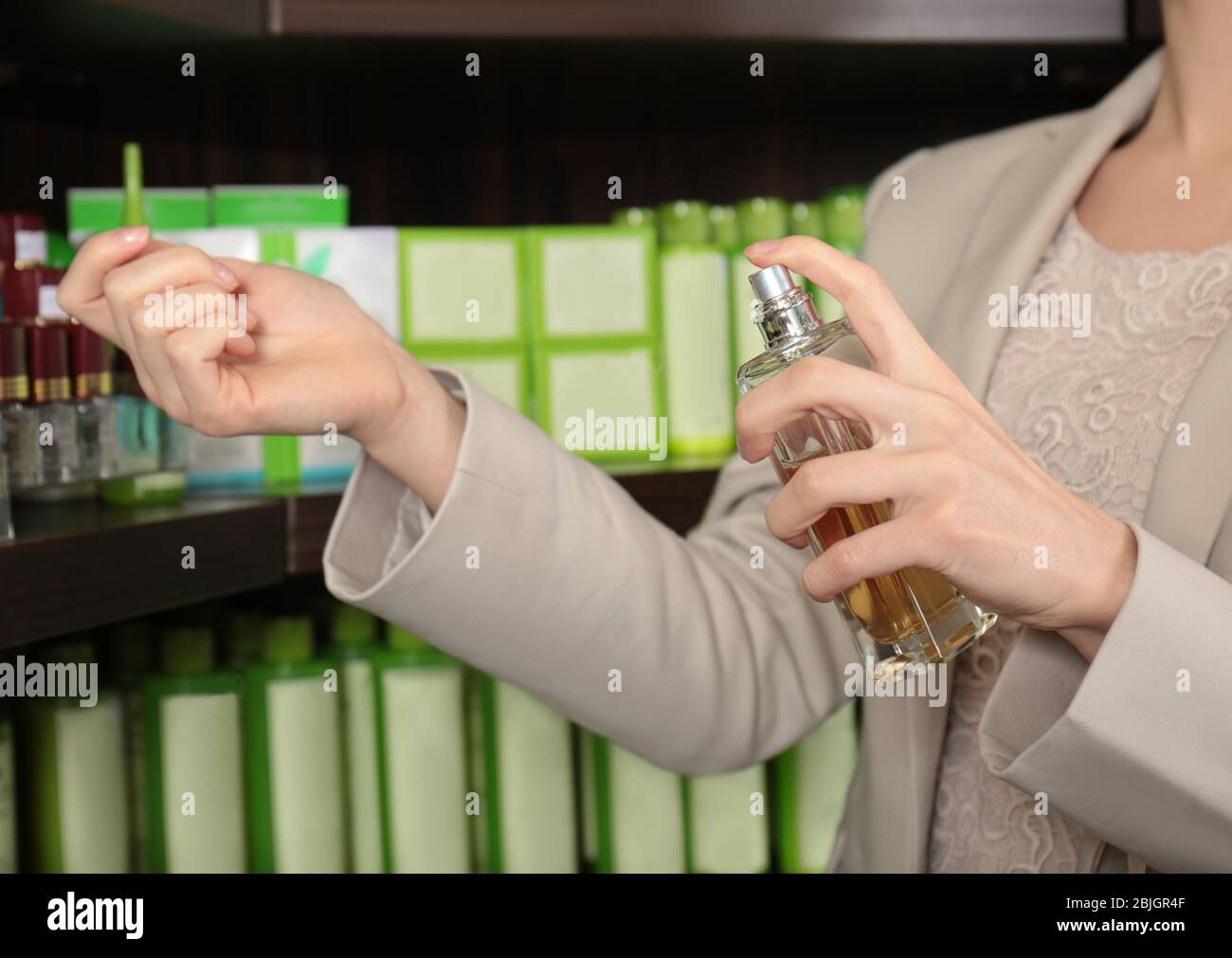 Young woman testing perfume on skin in store Stock Photo - Alamy