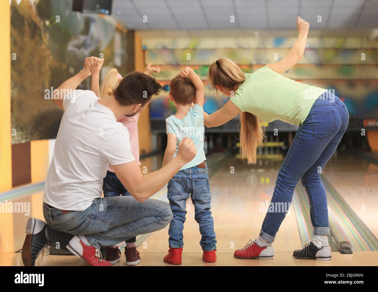 Family having fun at bowling club Stock Photo - Alamy