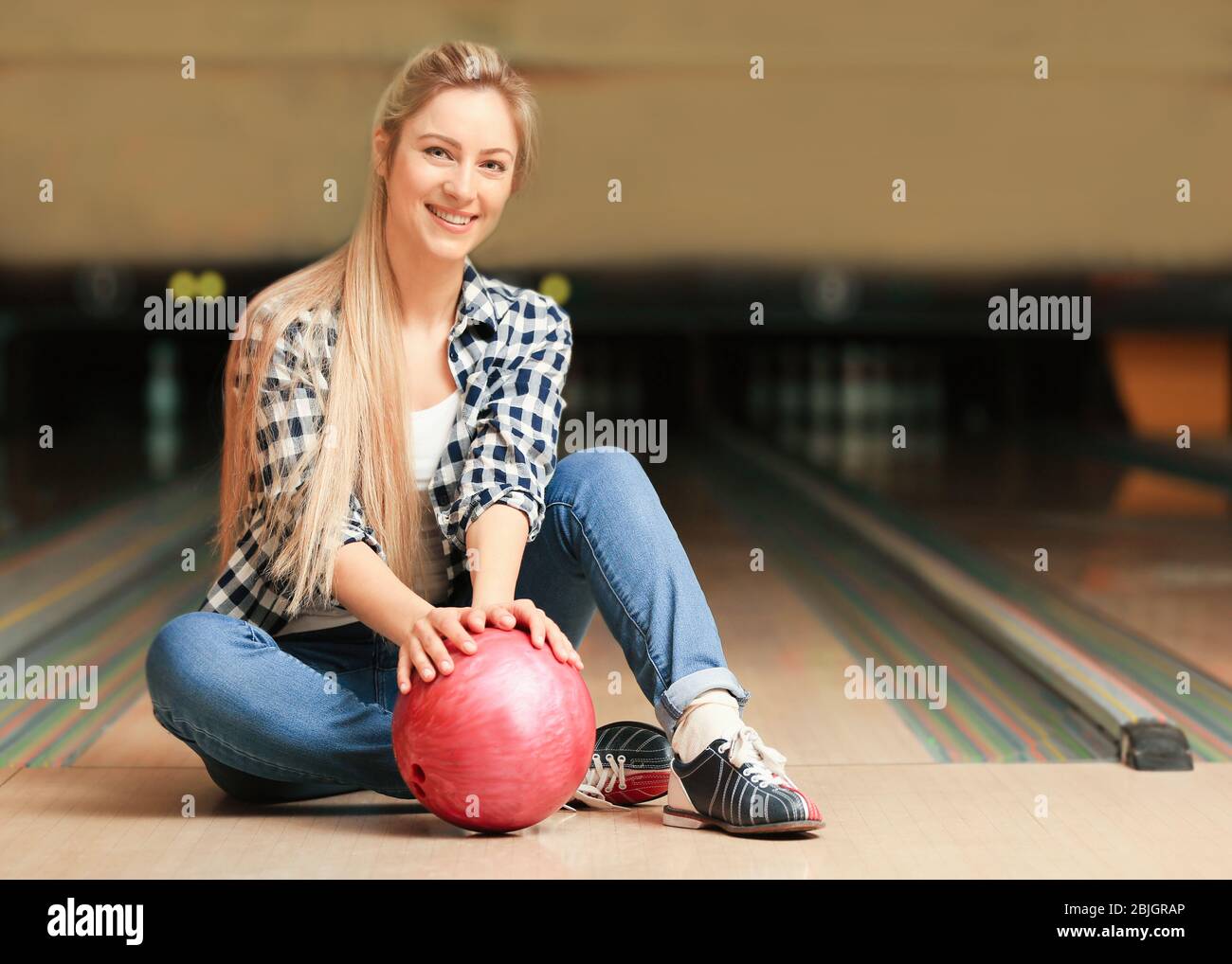 Beautiful young woman with ball in bowling club Stock Photo - Alamy