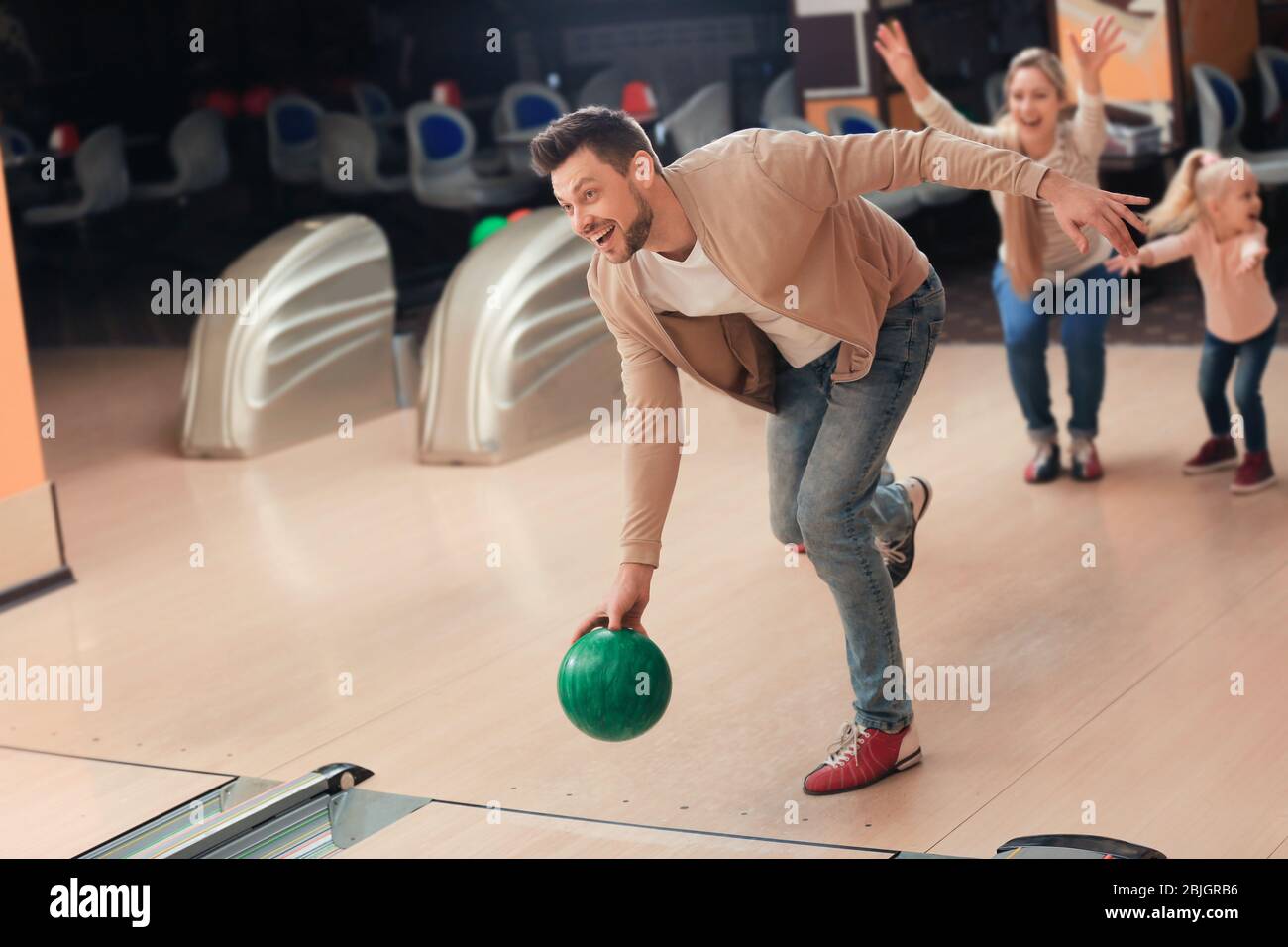 Family having fun at bowling club Stock Photo - Alamy