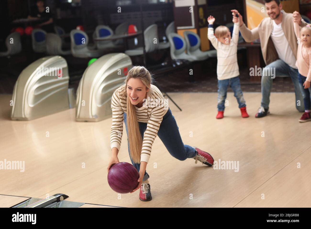Family having fun at bowling club Stock Photo - Alamy