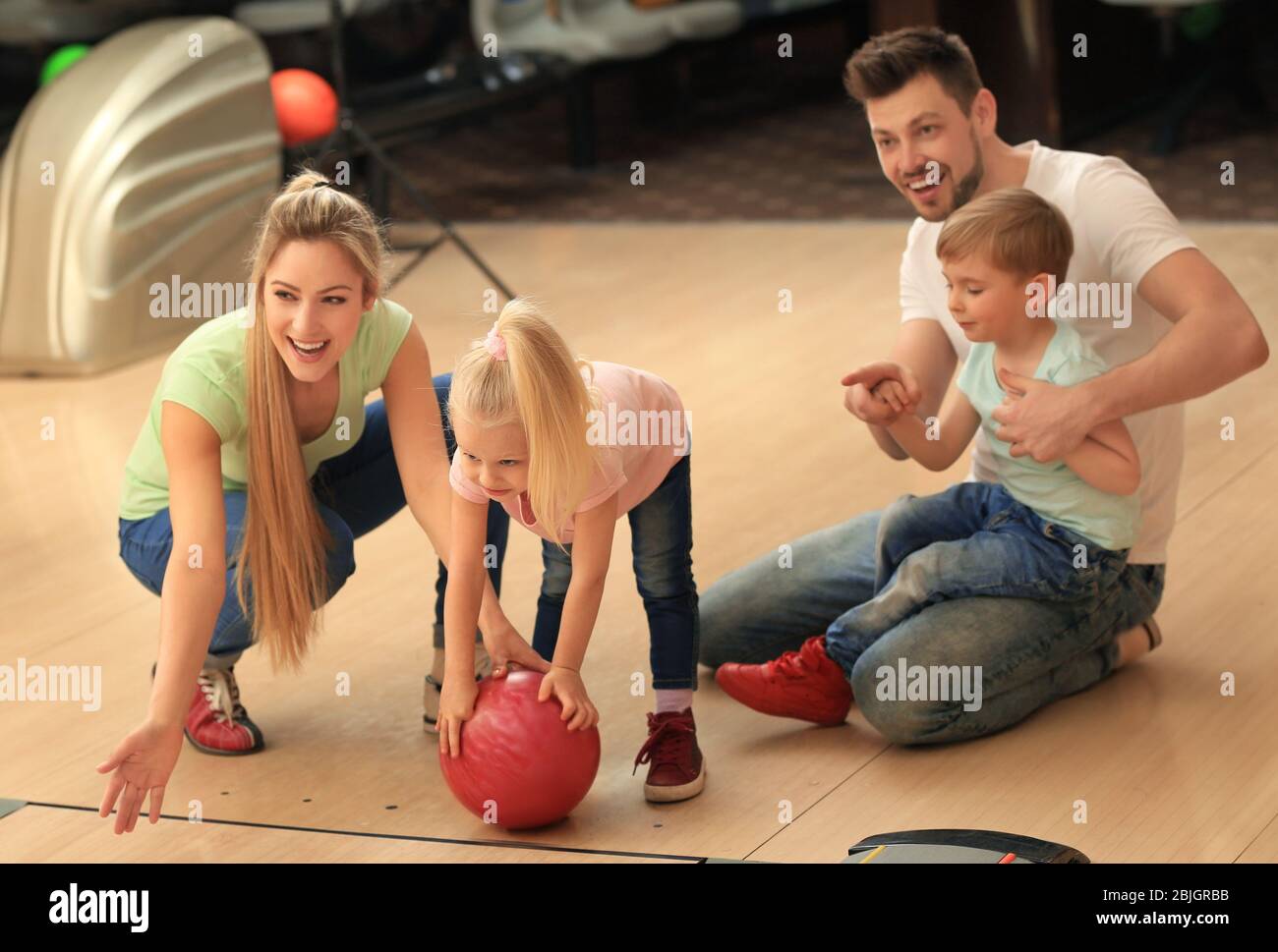 Family having fun at bowling club Stock Photo - Alamy