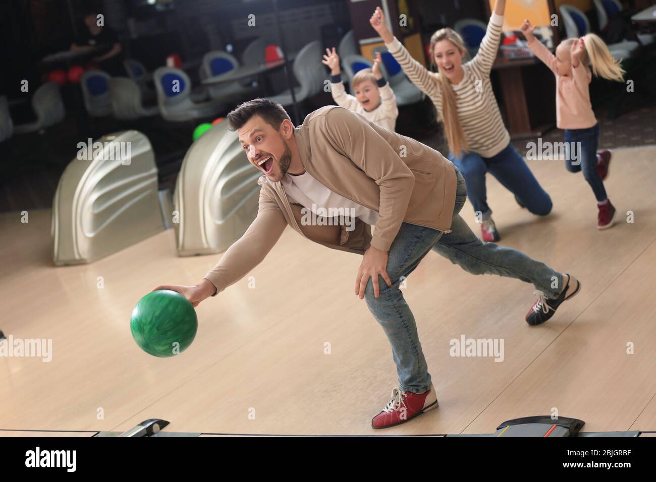 Family having fun at bowling club Stock Photo - Alamy