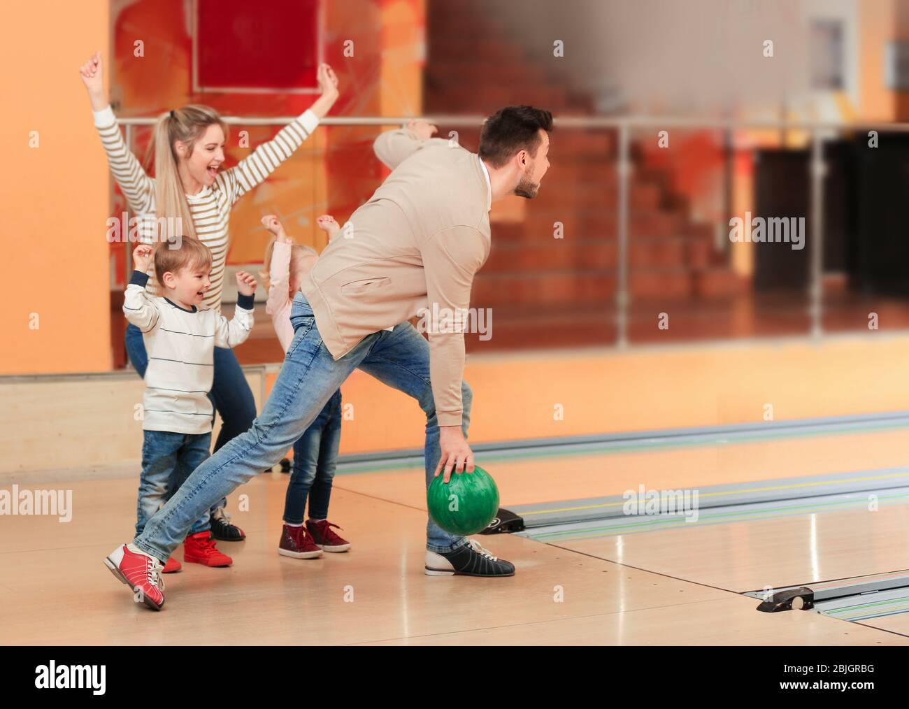 Family having fun at bowling club Stock Photo - Alamy