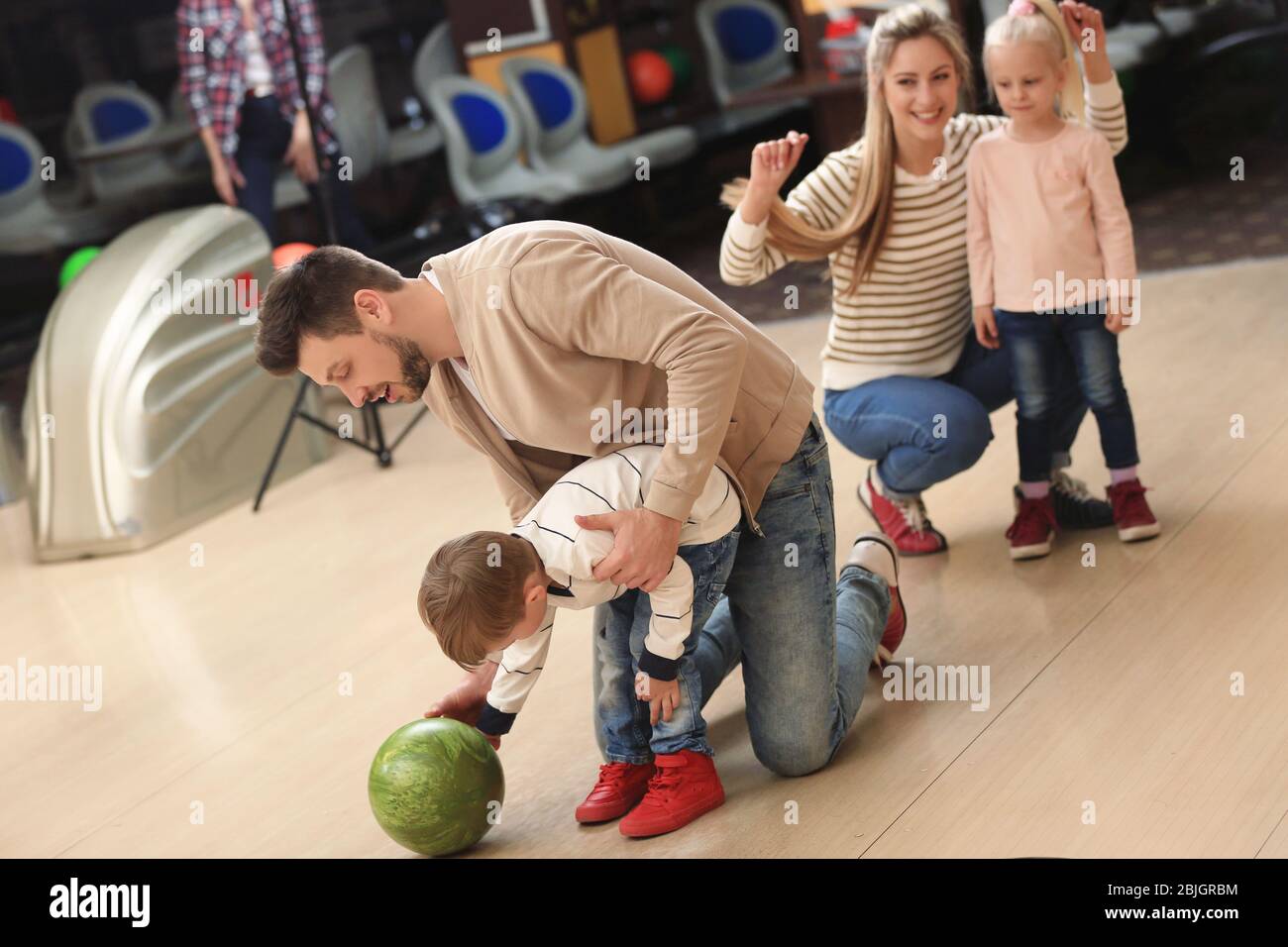Family having fun at bowling club Stock Photo - Alamy
