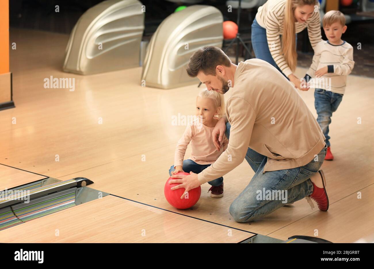 Family having fun at bowling club Stock Photo - Alamy