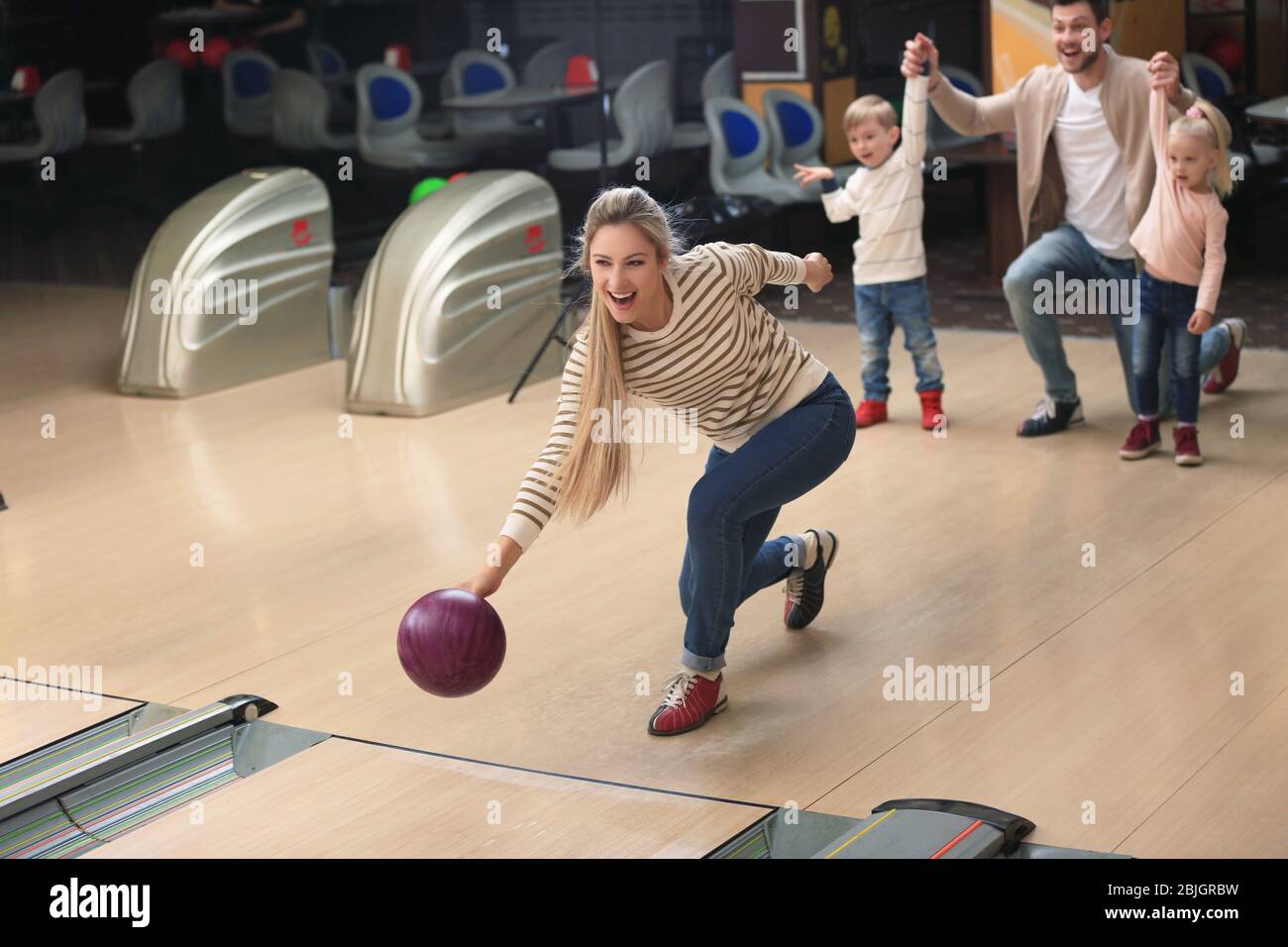 Family having fun at bowling club Stock Photo - Alamy
