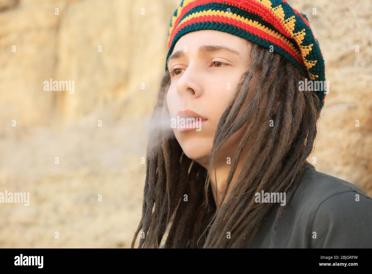 Young boy smoking weed on blurred background Stock Photo - Alamy