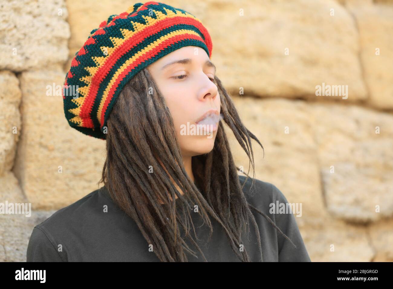 Young boy smoking weed on blurred background Stock Photo - Alamy