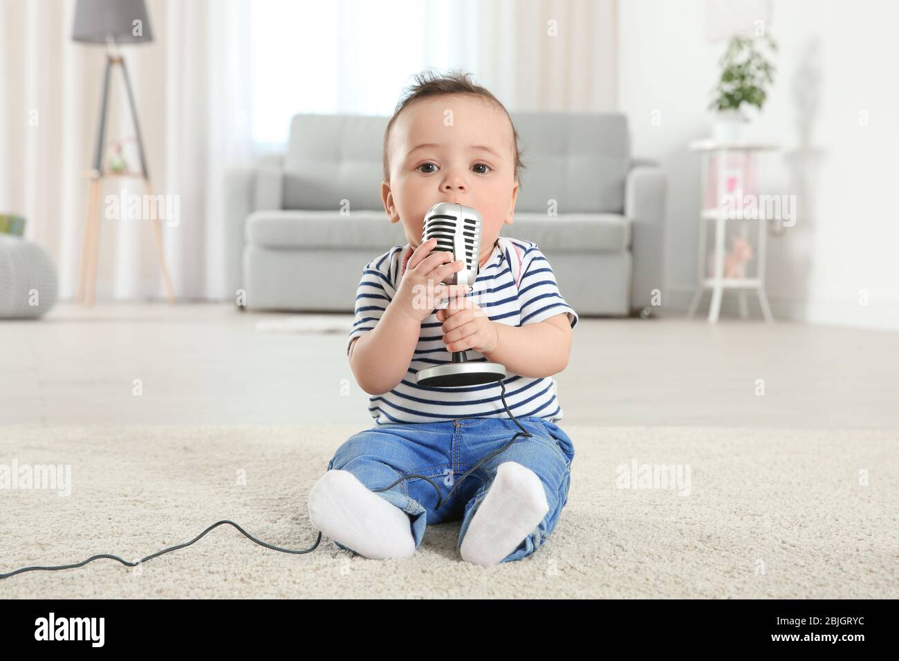Cute little baby with microphone at home Stock Photo - Alamy