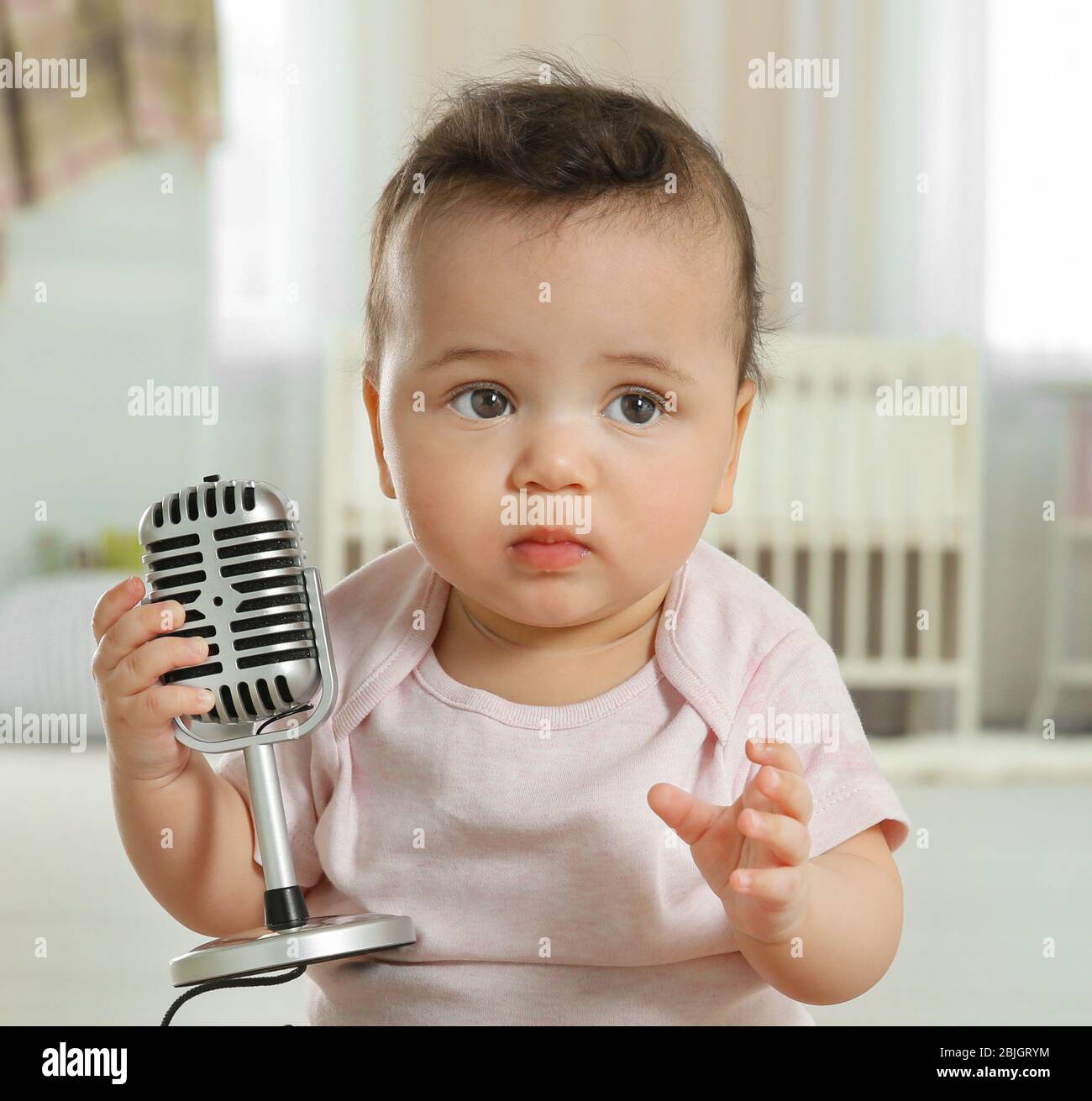 Cute little baby with microphone at home Stock Photo - Alamy