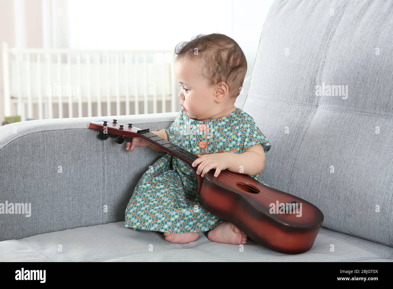 Cute little baby with guitar at home Stock Photo - Alamy