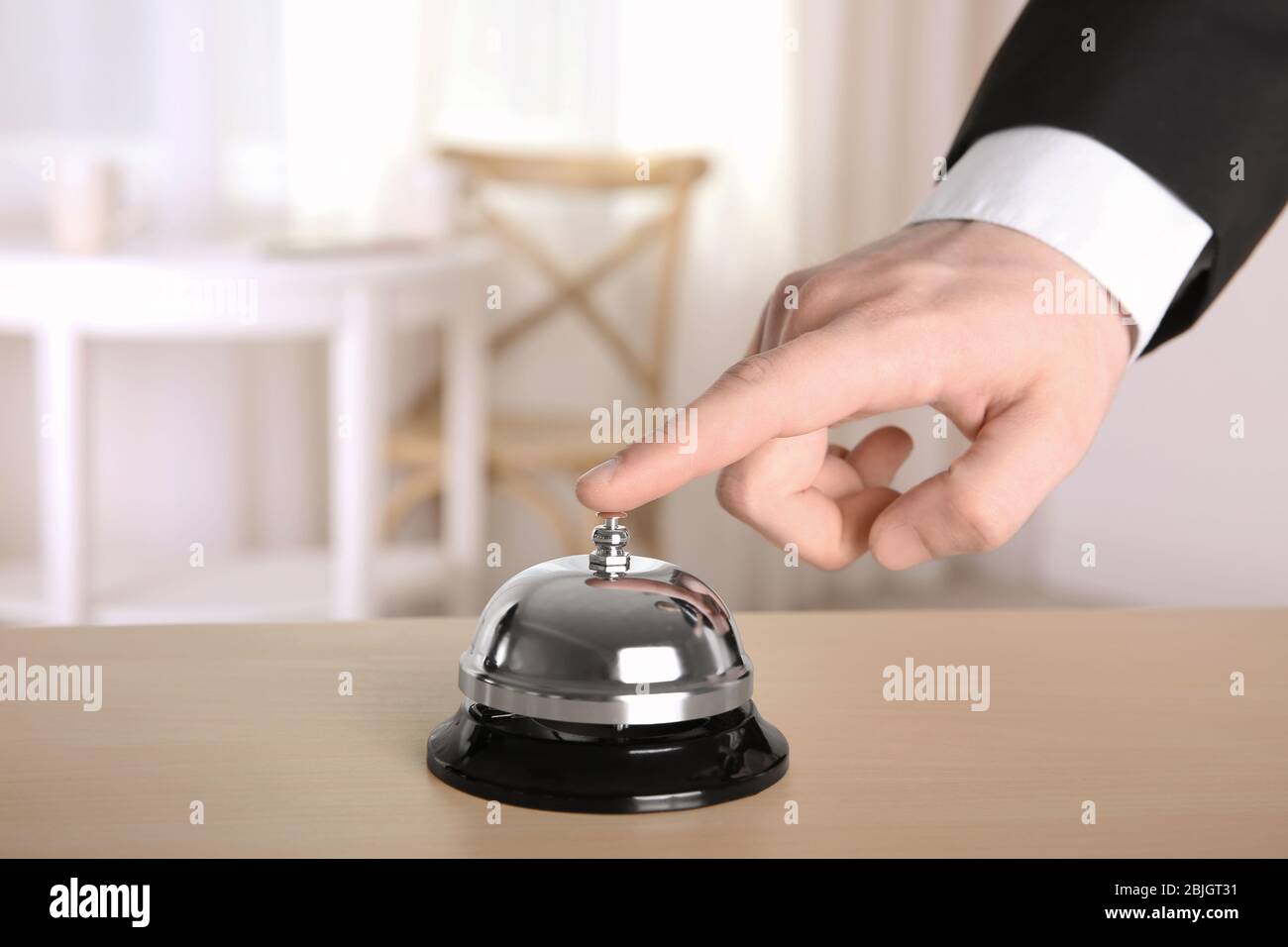 Man ringing service bell in hotel lobby Stock Photo - Alamy