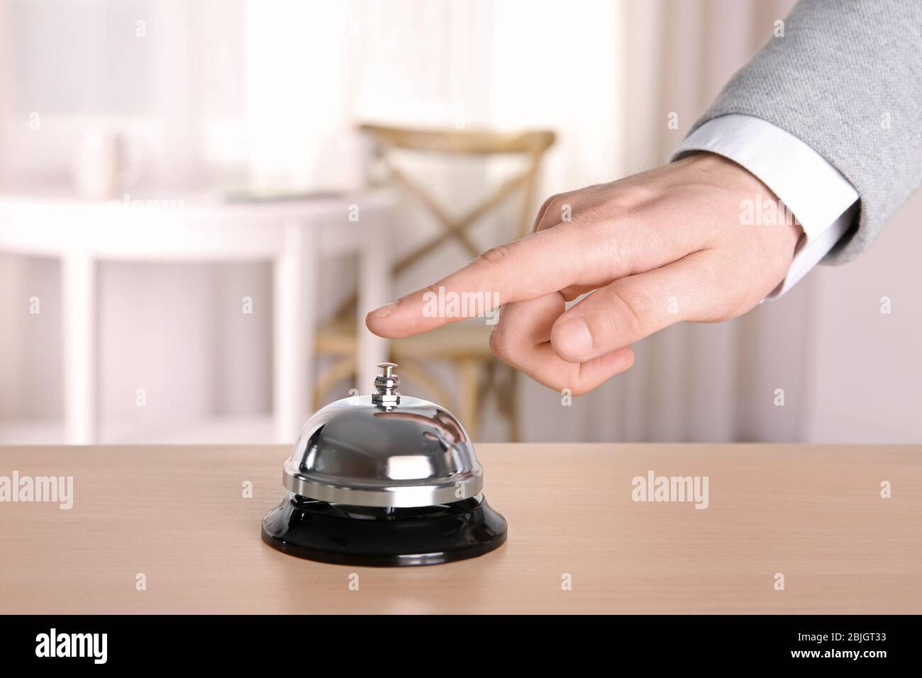 Man ringing service bell in hotel lobby Stock Photo - Alamy