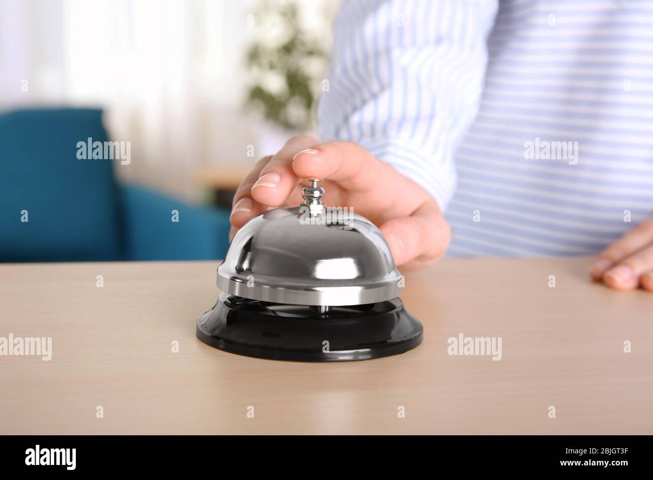 Businesswoman ringing service bell in hotel lobby Stock Photo - Alamy