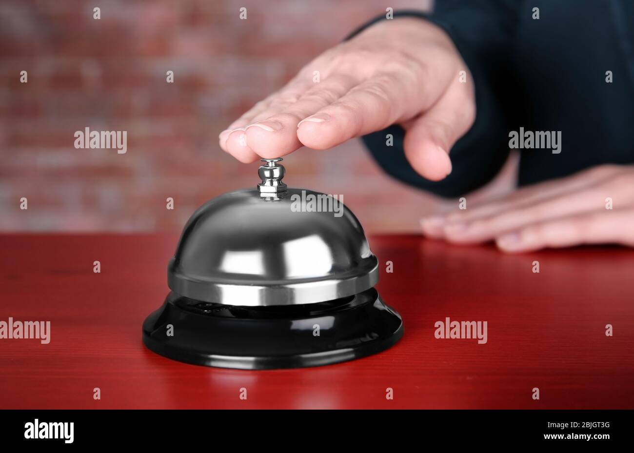 Woman ringing service bell in hotel lobby Stock Photo - Alamy