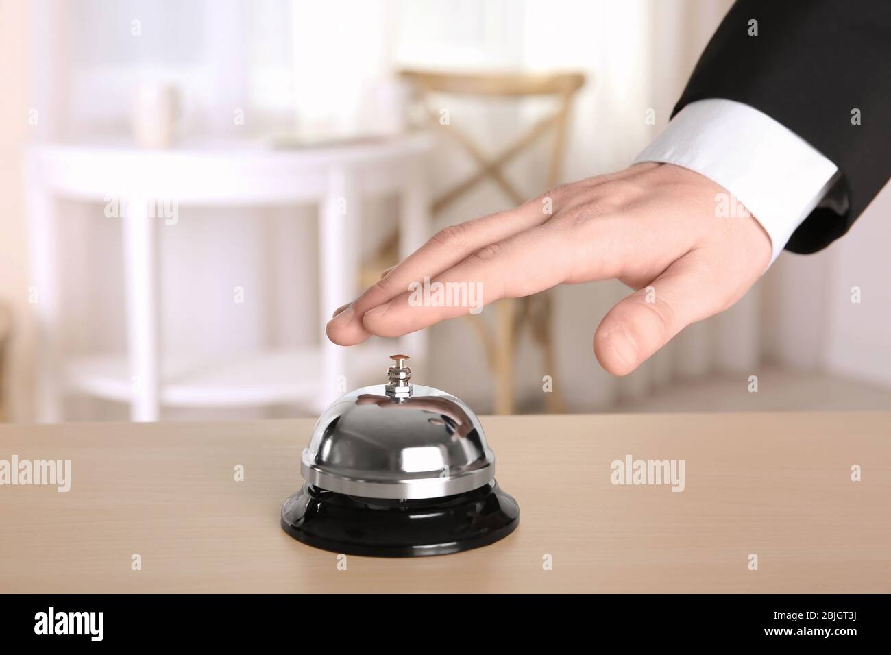 Man ringing service bell in hotel lobby Stock Photo - Alamy