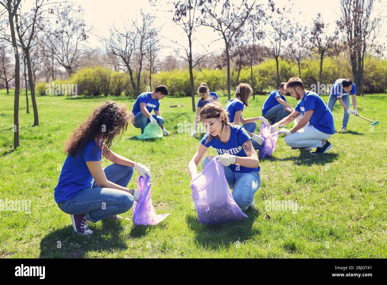 Group of young volunteers gathering garbage in park Stock Photo - Alamy