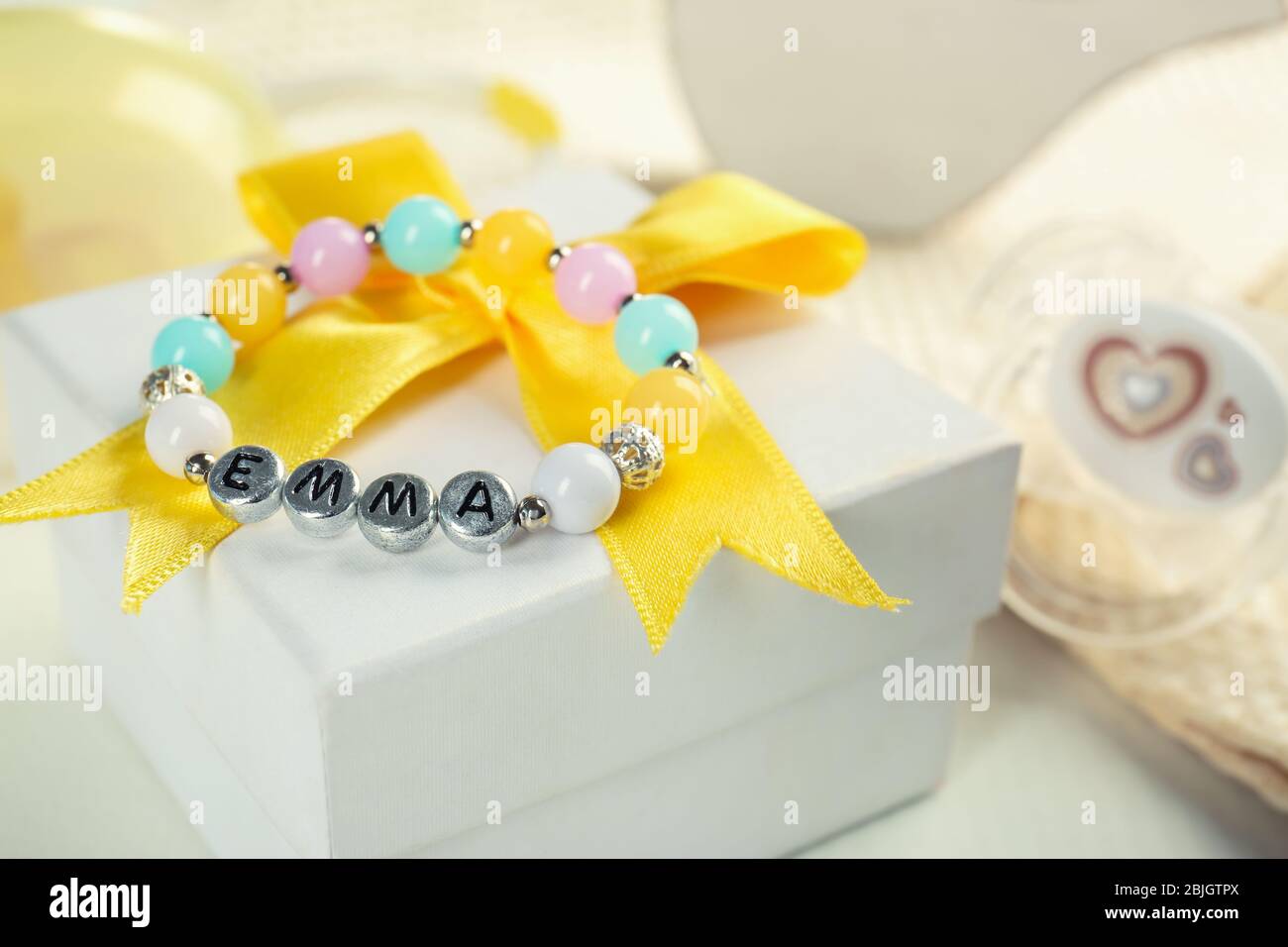 Bracelet with baby name Emma on white gift box Stock Photo - Alamy