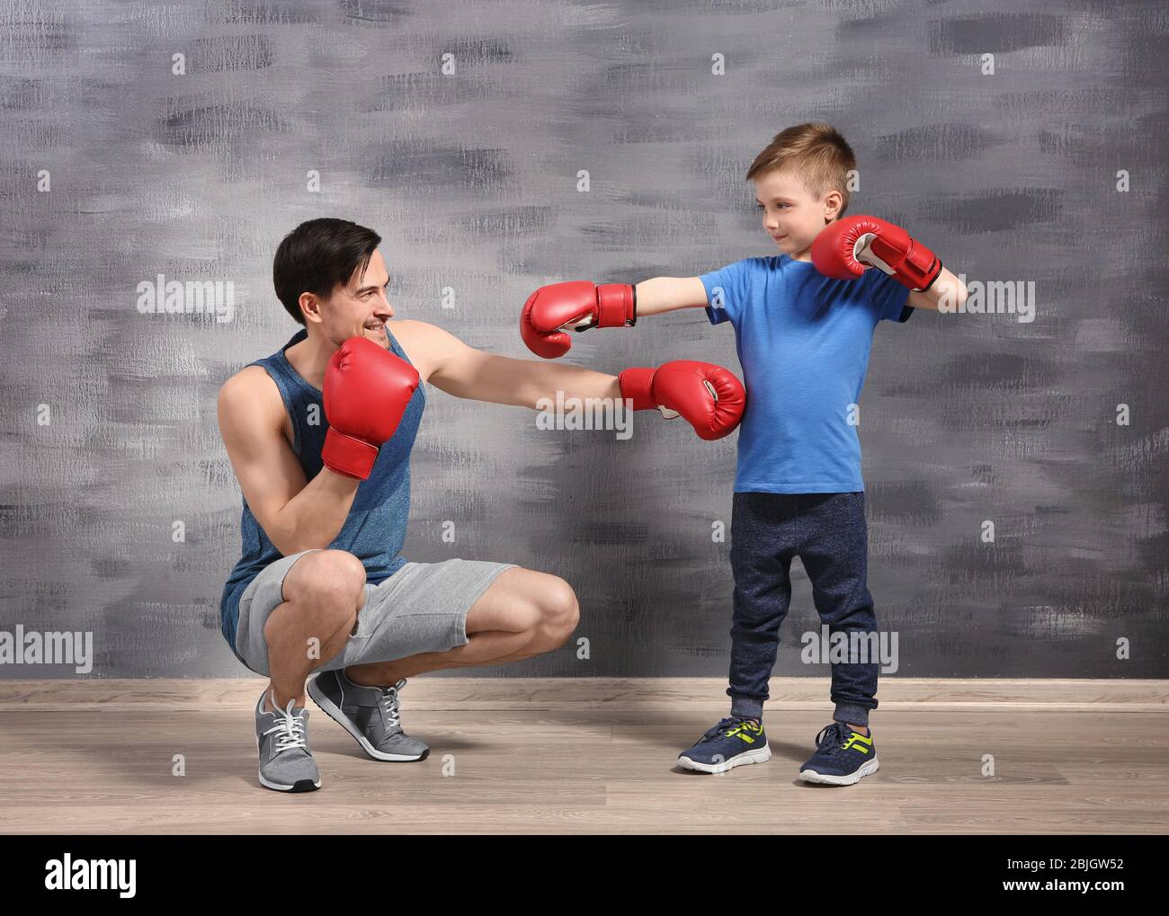 Father and son during boxing training near color wall Stock Photo - Alamy