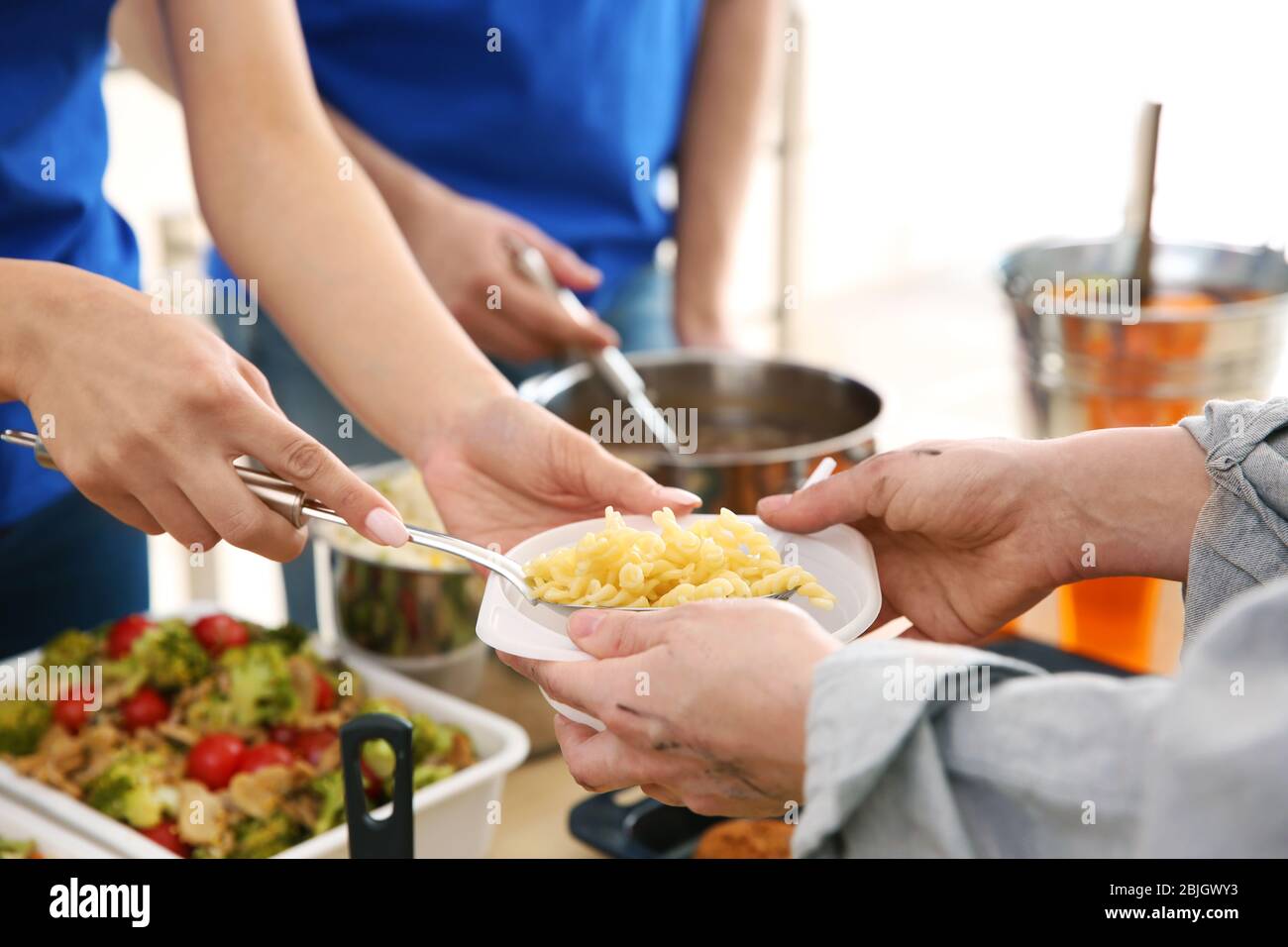 Volunteers giving food to poor people. Poverty concept Stock Photo - Alamy