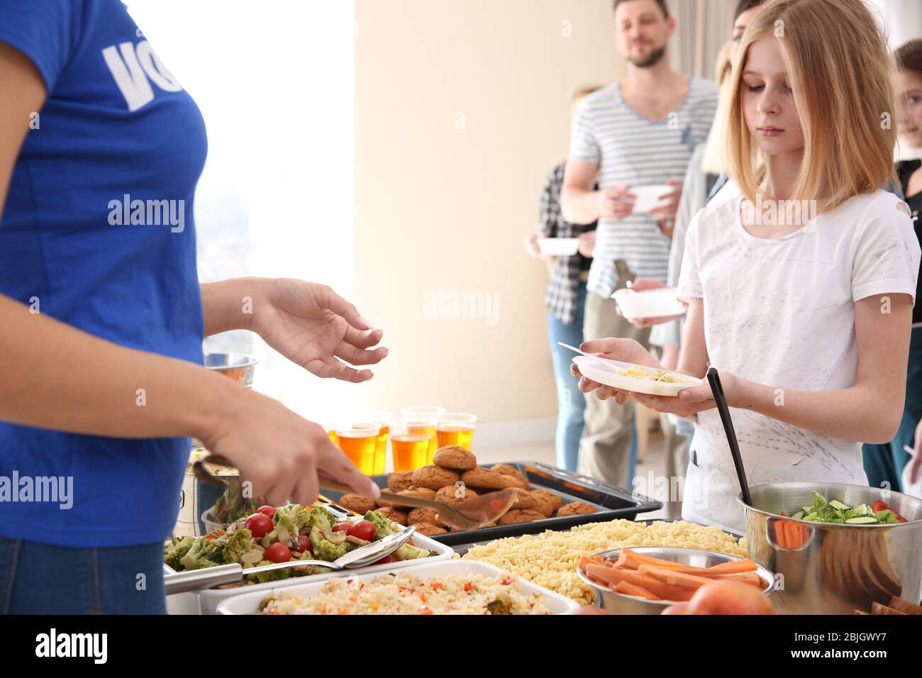Volunteer giving food to poor people. Poverty concept Stock Photo - Alamy