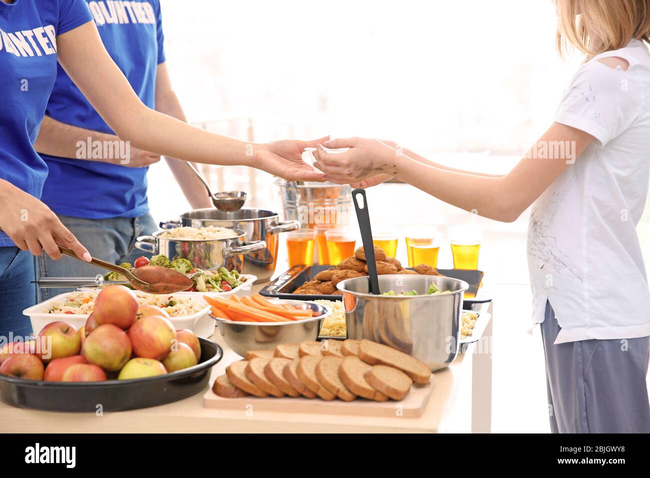 Volunteers giving food to poor girl. Poverty concept Stock Photo - Alamy