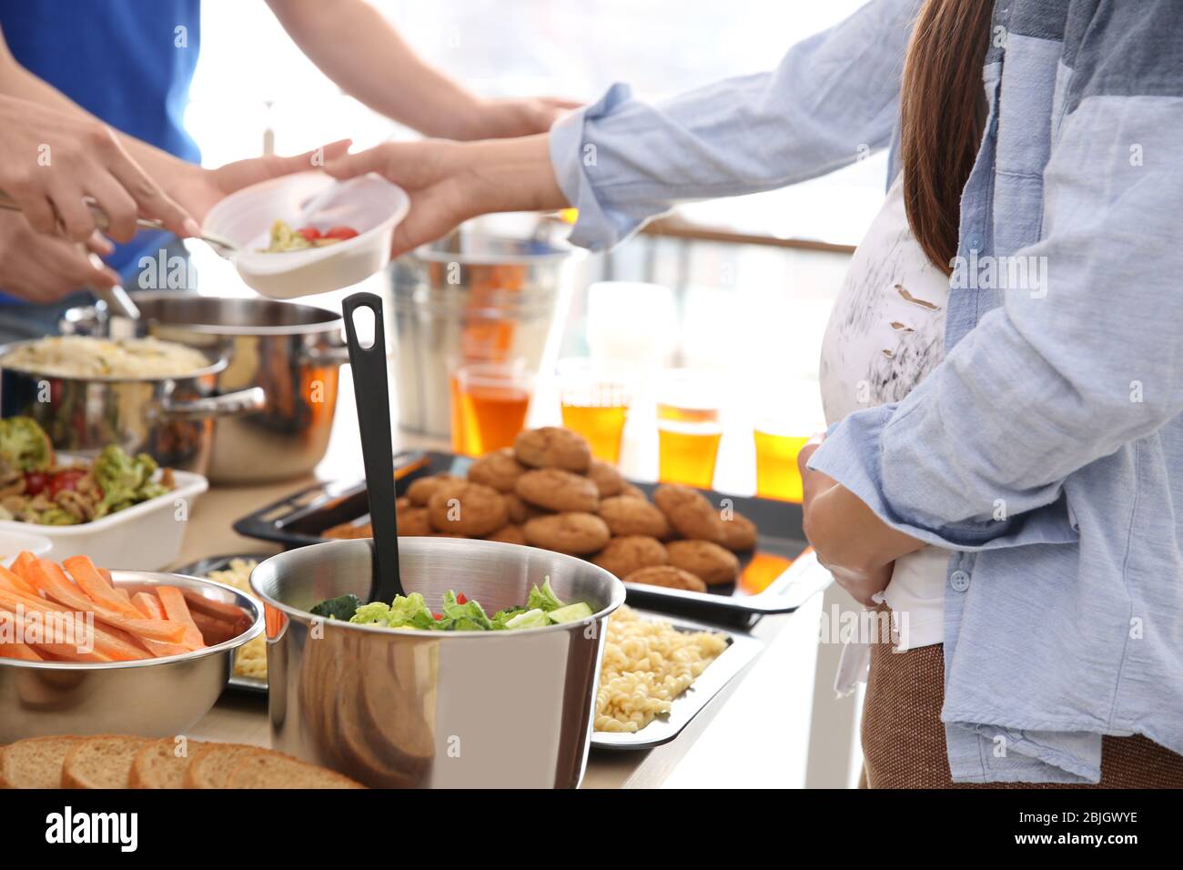 Pregnant woman receiving food from volunteer. Poverty concept Stock ...