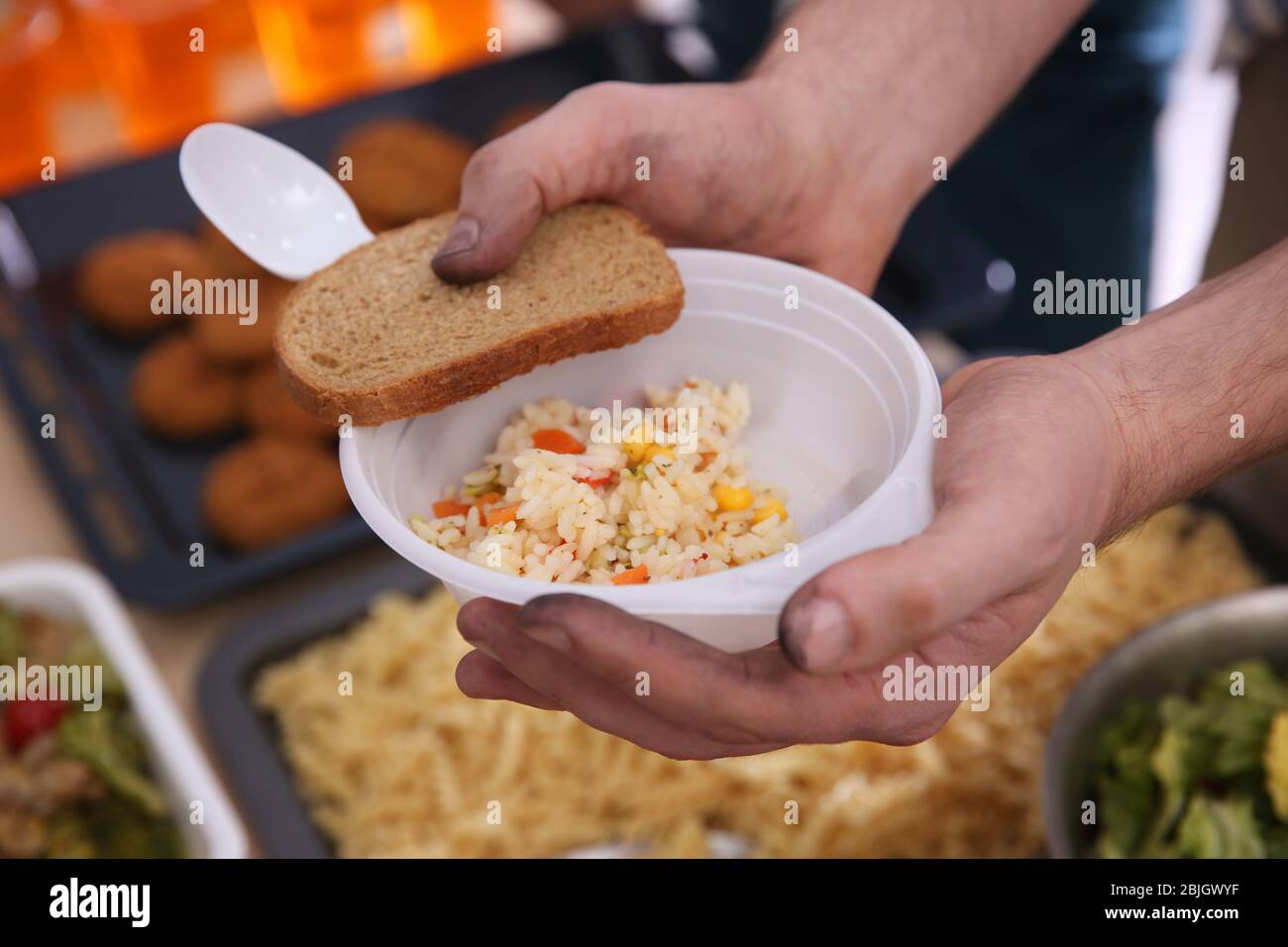 Hands of poor man holding bowl with rice and bread. Poverty concept ...