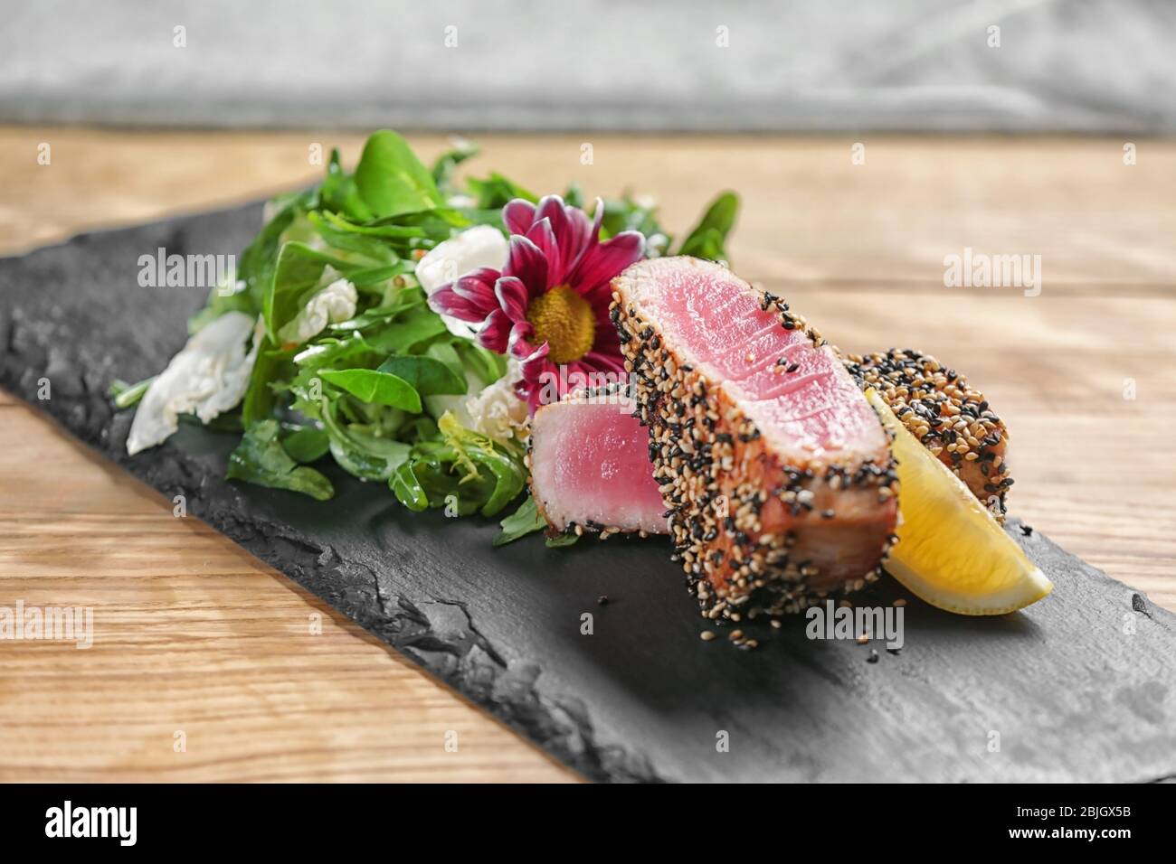 Slate plate with delicious tuna fillet on table Stock Photo - Alamy