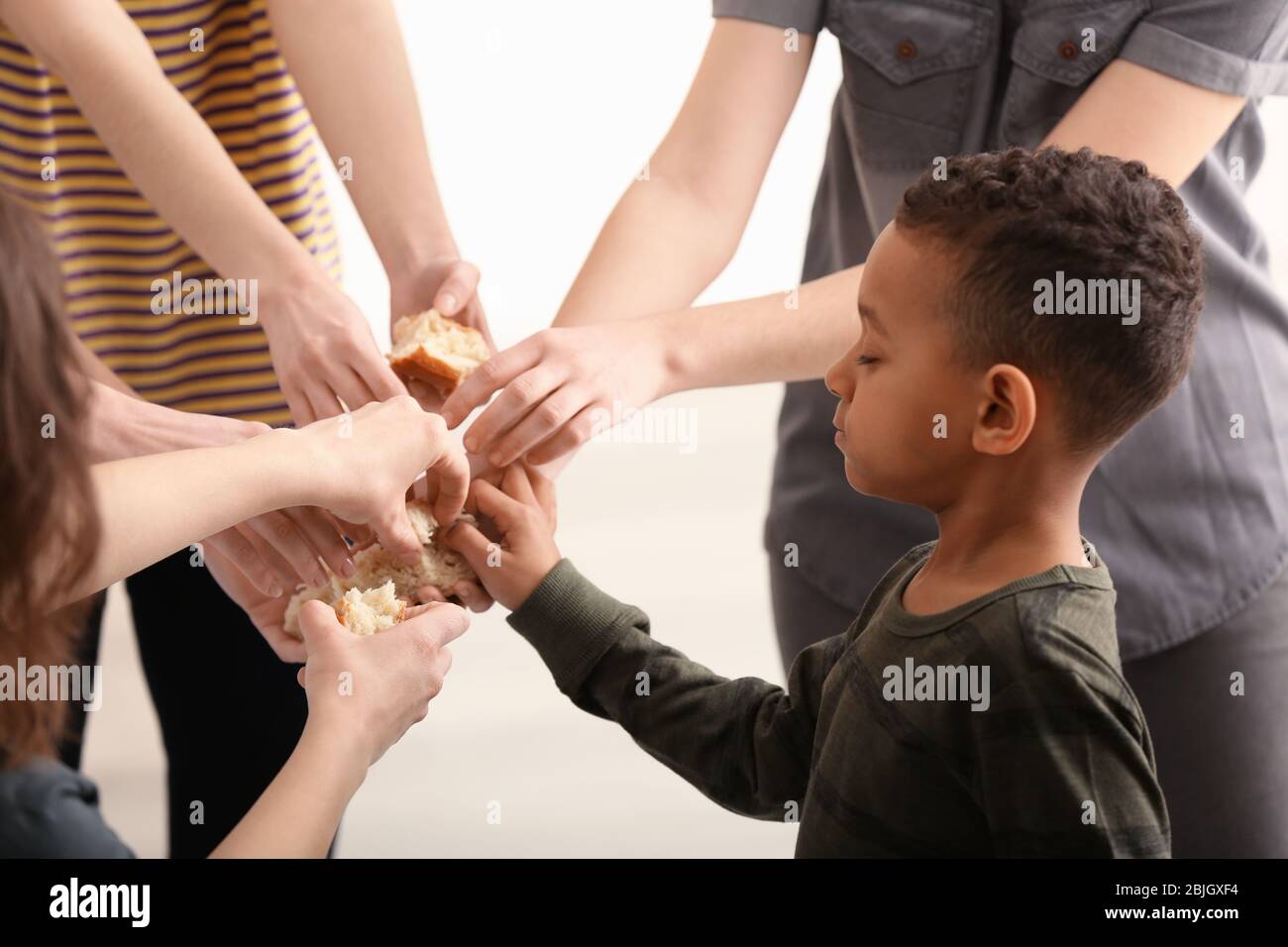 Cute little boy taking piece of bread from hand. Poverty concept Stock ...