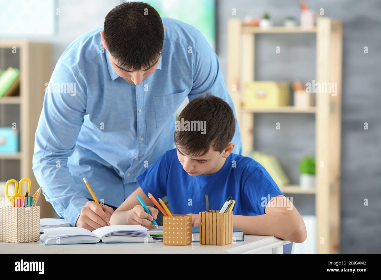 Father and son doing homework together indoors Stock Photo - Alamy