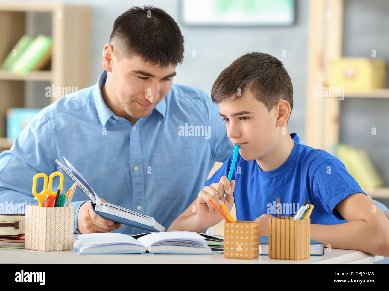 Father and son doing homework together indoors Stock Photo - Alamy