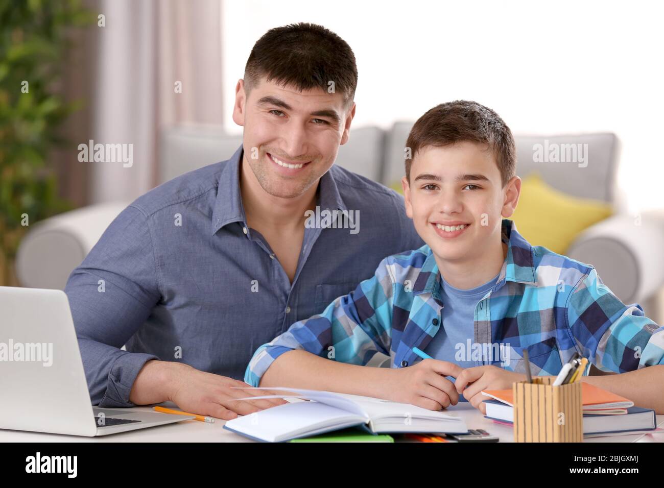 Father and son doing homework together indoors Stock Photo - Alamy