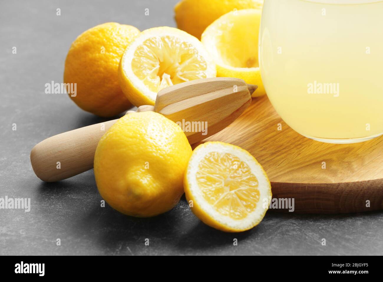 Squeezer and lemons on dark background Stock Photo - Alamy