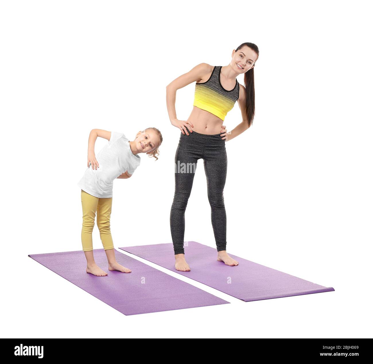 Mother and daughter doing exercise on white background Stock Photo - Alamy