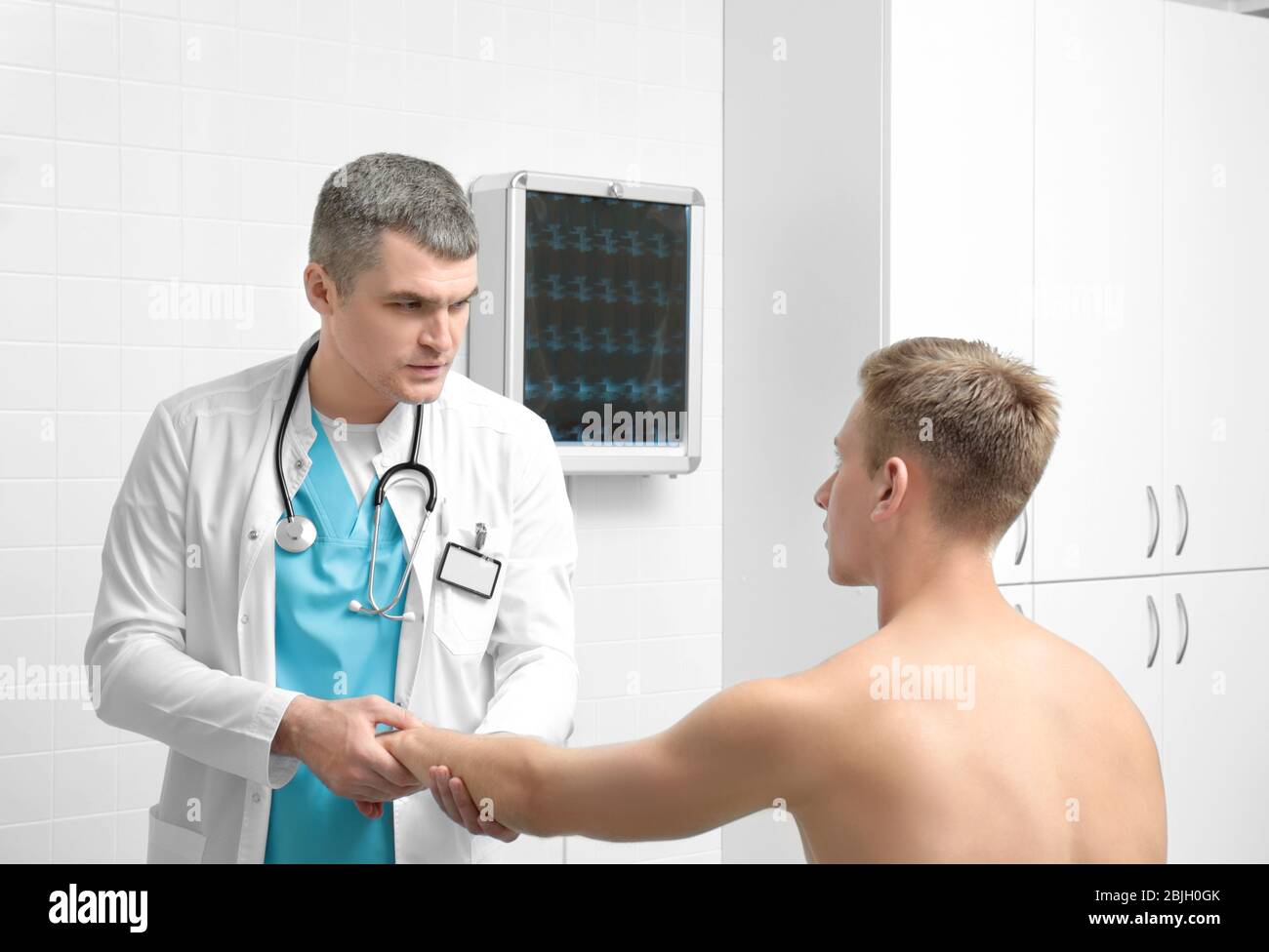 Professional male orthopedist examining young hi-res stock photography ...