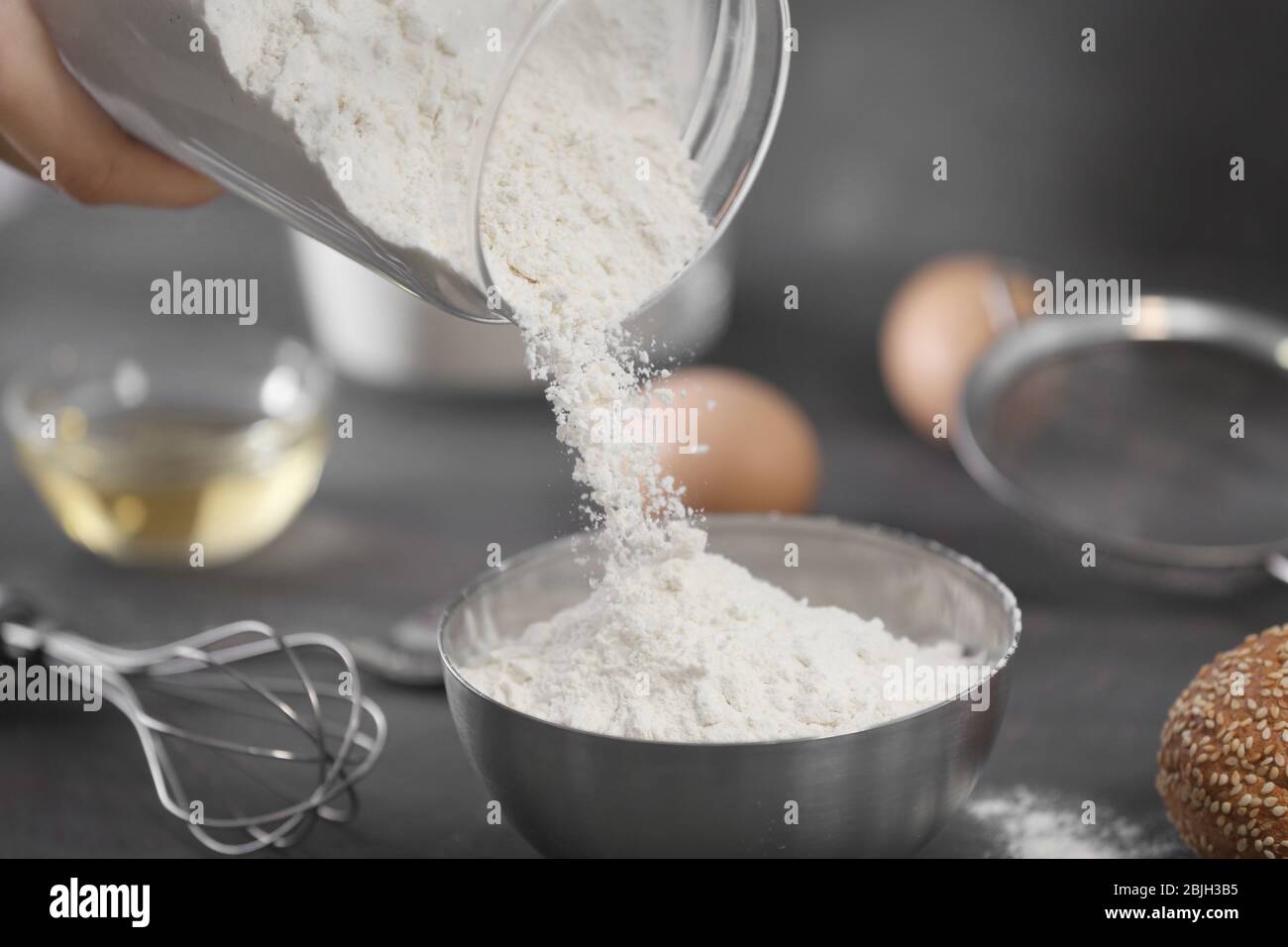 Filling metal bowl with flour Stock Photo - Alamy
