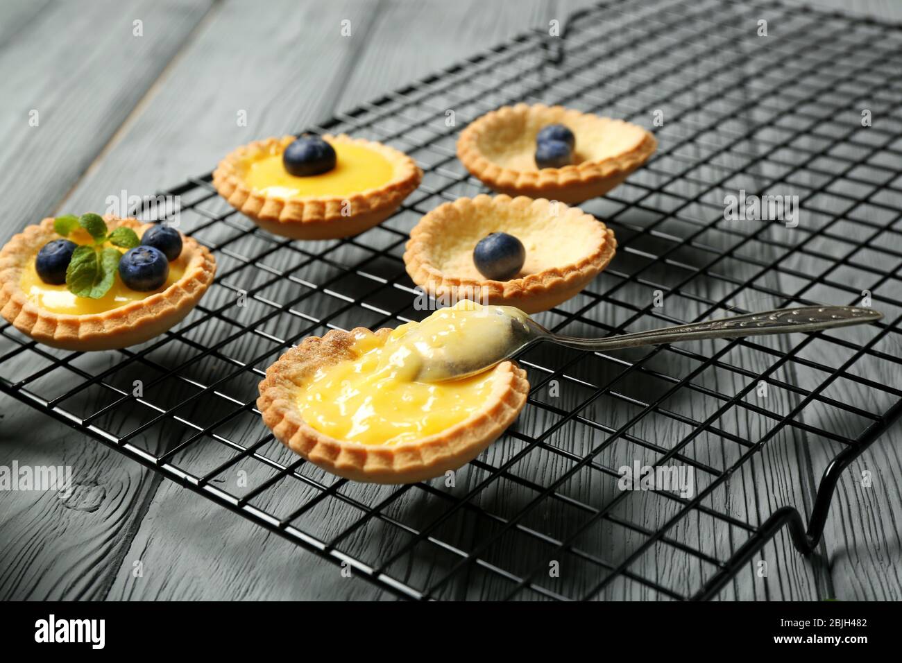 Cooling rack with delicious crispy tarts on table Stock Photo - Alamy
