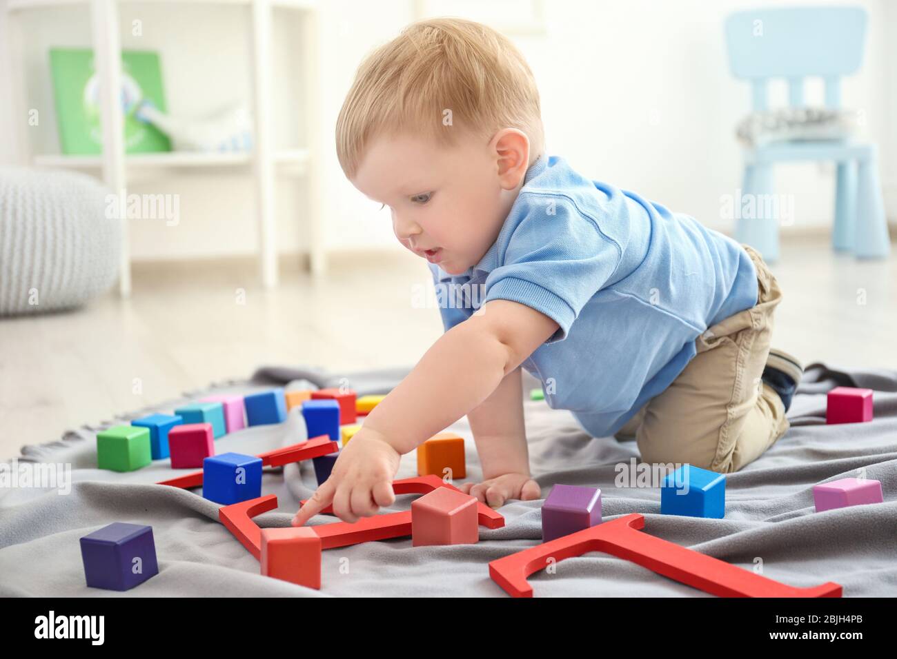 Cute little boy playing on floor at home Stock Photo - Alamy