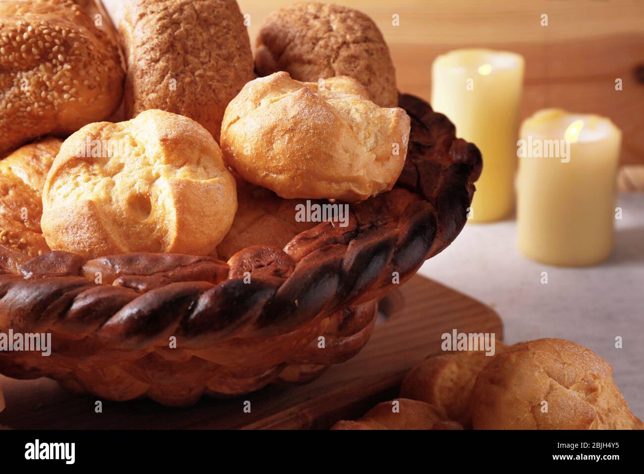 Baked basket with fresh buns on table, closeup Stock Photo - Alamy
