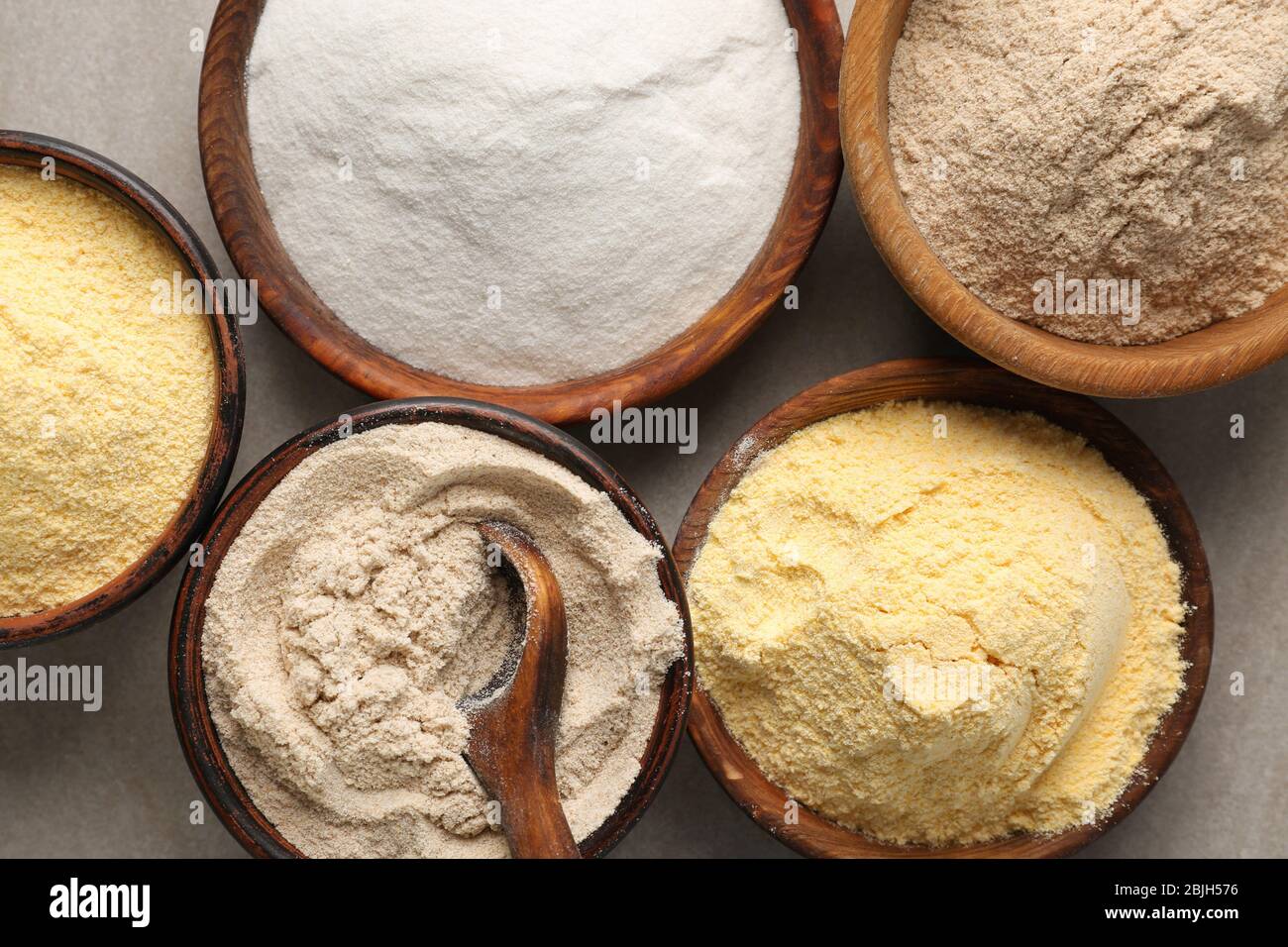 Wooden bowls with different types of flour on table, closeup Stock ...