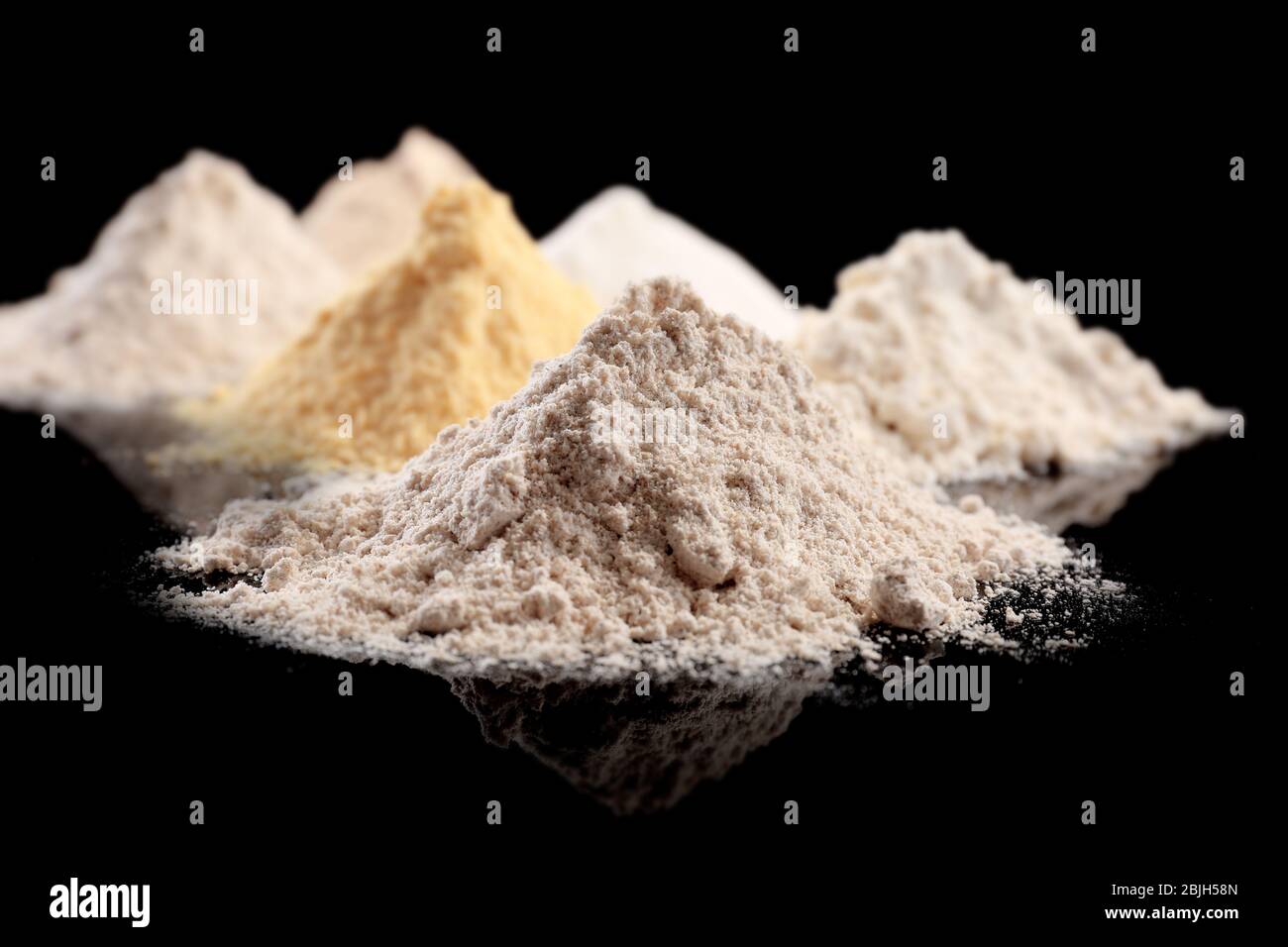 Different types of flour on black background Stock Photo - Alamy