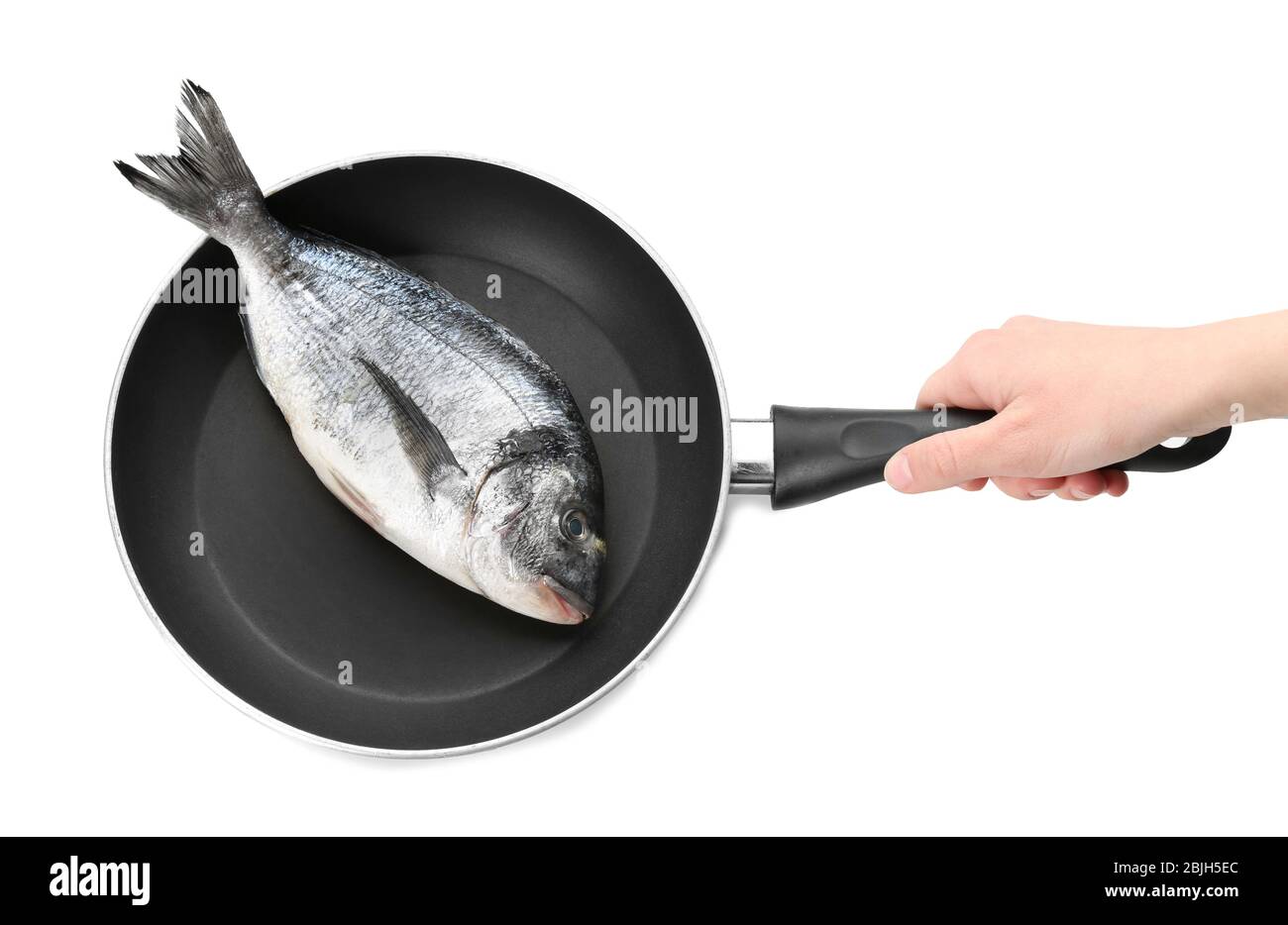 Female hand holding frying pan with fresh dorado fish on white ...