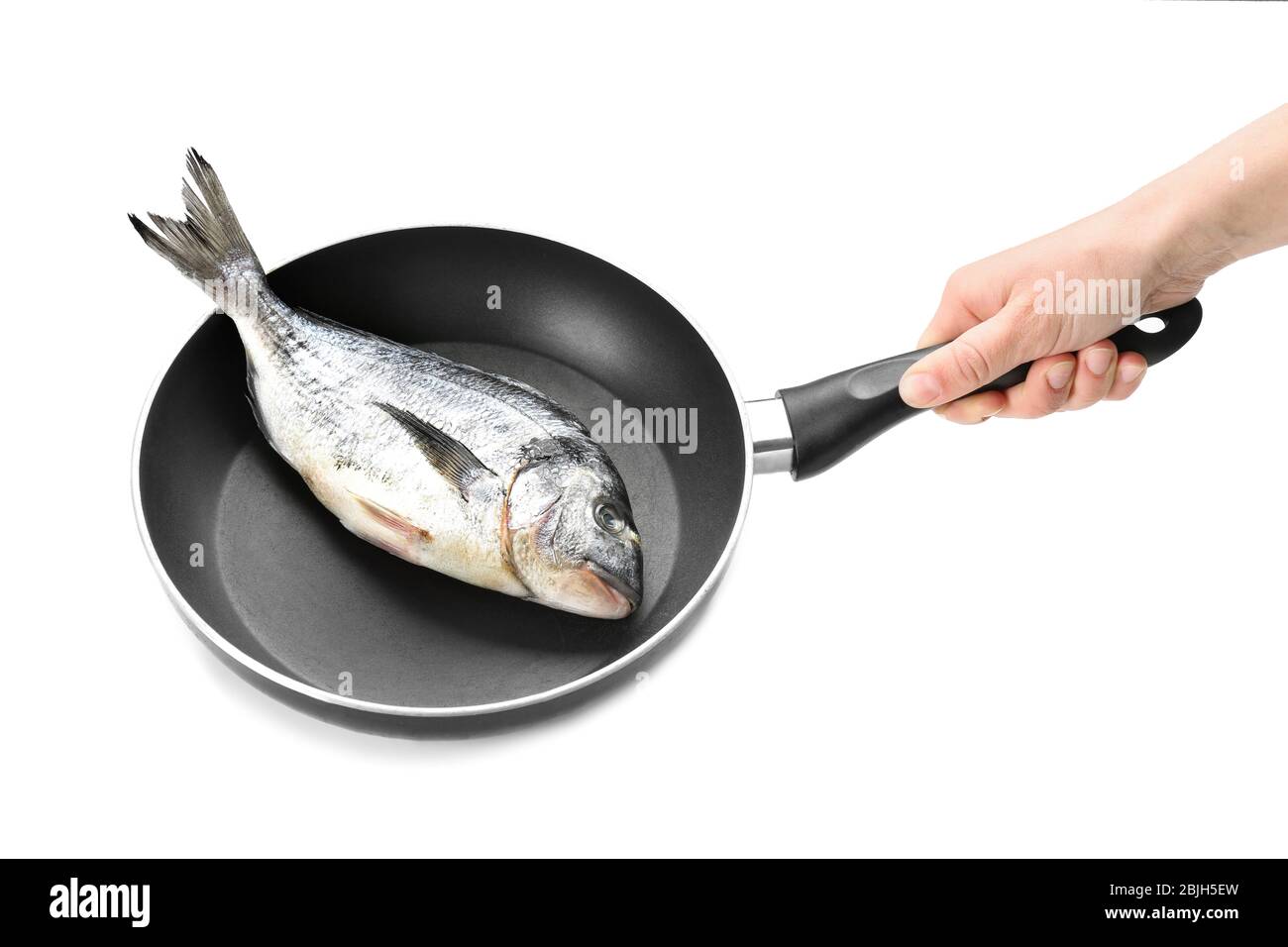 Female hand holding frying pan with fresh dorado fish on white ...