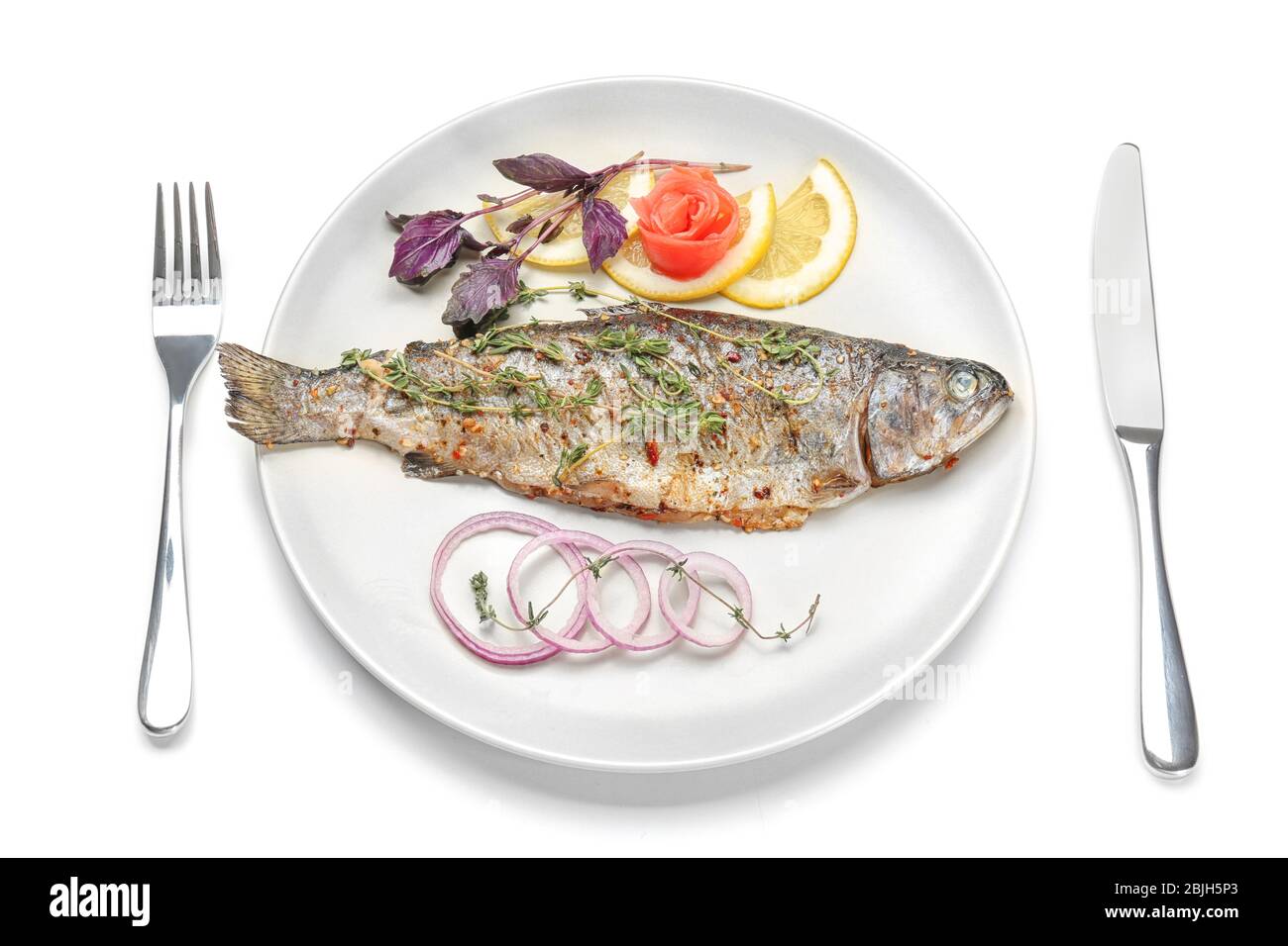 Plate with tasty fried fish and cutlery set on white background Stock ...