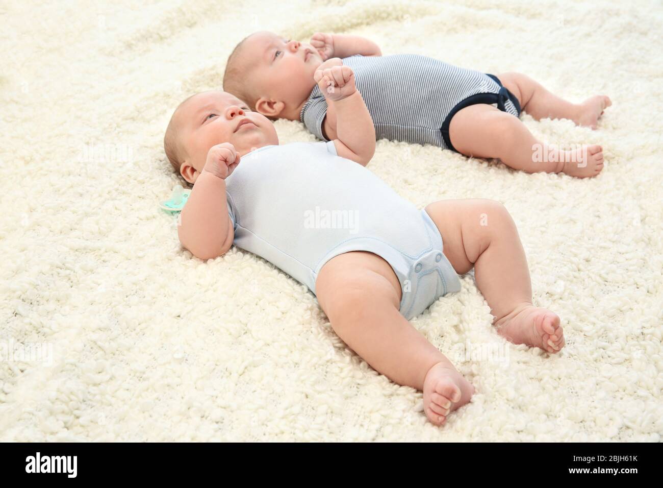 Cute little babies lying on bed at home Stock Photo - Alamy