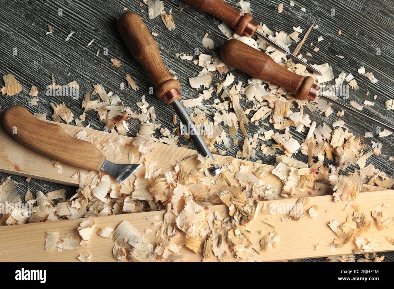 Set of tools, wooden boards and saw dust on table in carpenter's ...